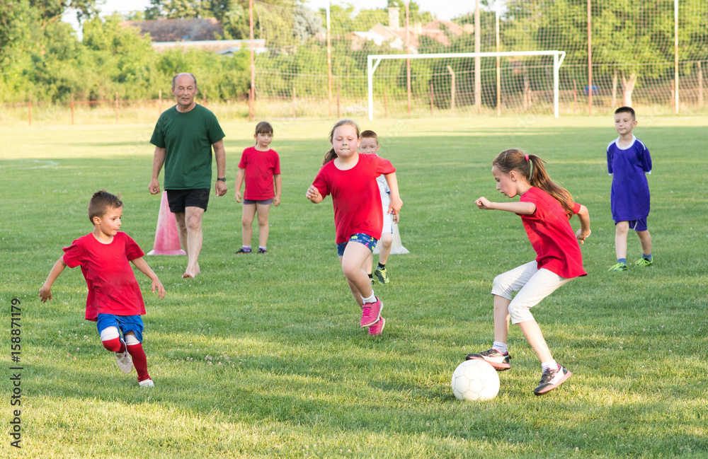 Kids soccer football - boys and girls play football match on soccer ...