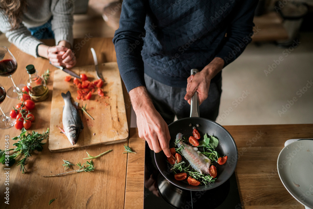 Mid section of young couple preparing fish at kitchen counter Stock ...