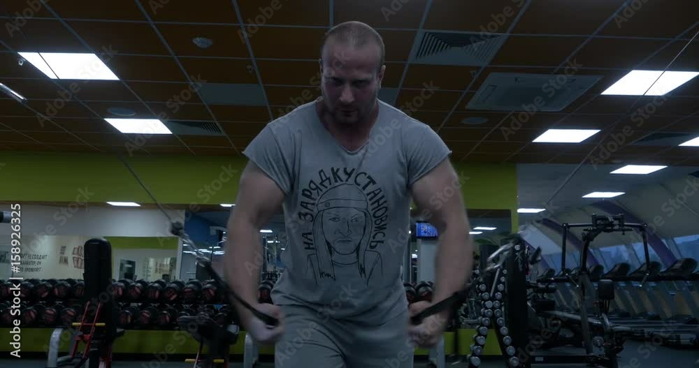 Bodybuilder doing butterfly on cable pull for better definition of his ...