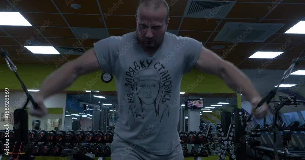 Bodybuilder doing butterfly on cable pull for better definition of his ...