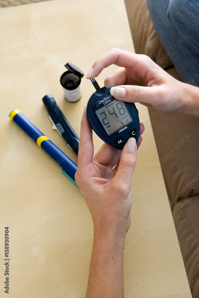 Model Woman using glucometer with a lancing device and a pen injector ...