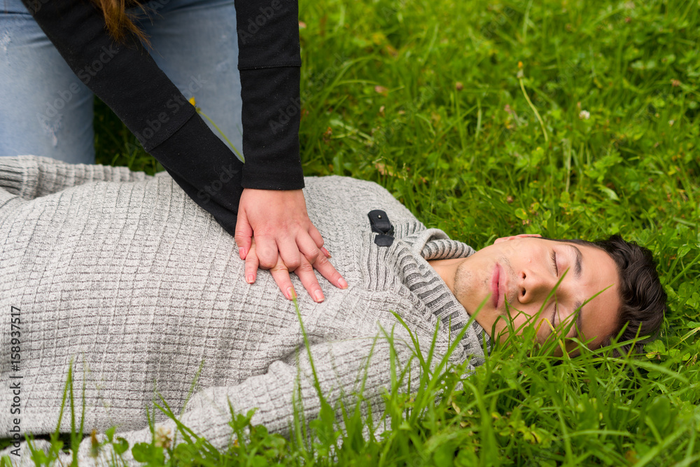 Beautiful woman giving first aid to a handsome young man ...