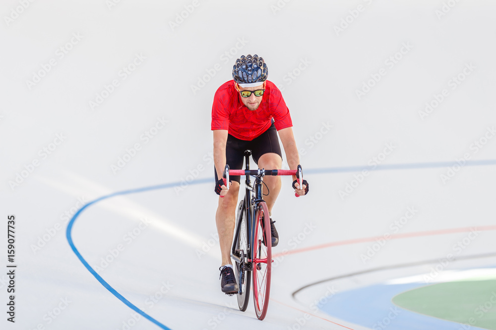 Bicyclist on cycle track outdoor. Active man racing at white velodrome ...