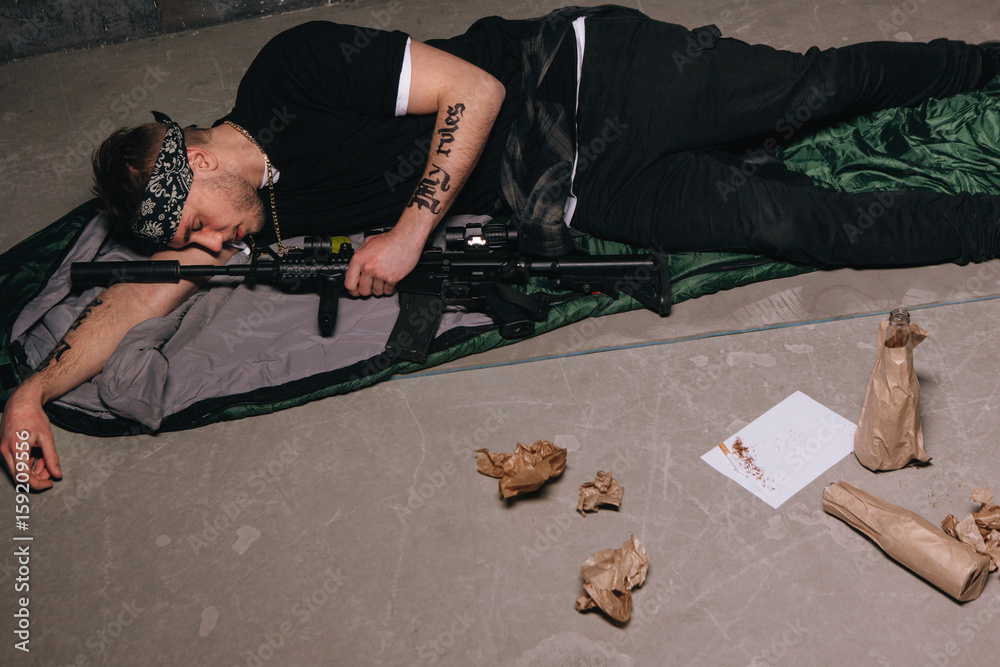 Gangster sleep with rifle. Bad habits. Cigarette, alcohol, weapon top ...