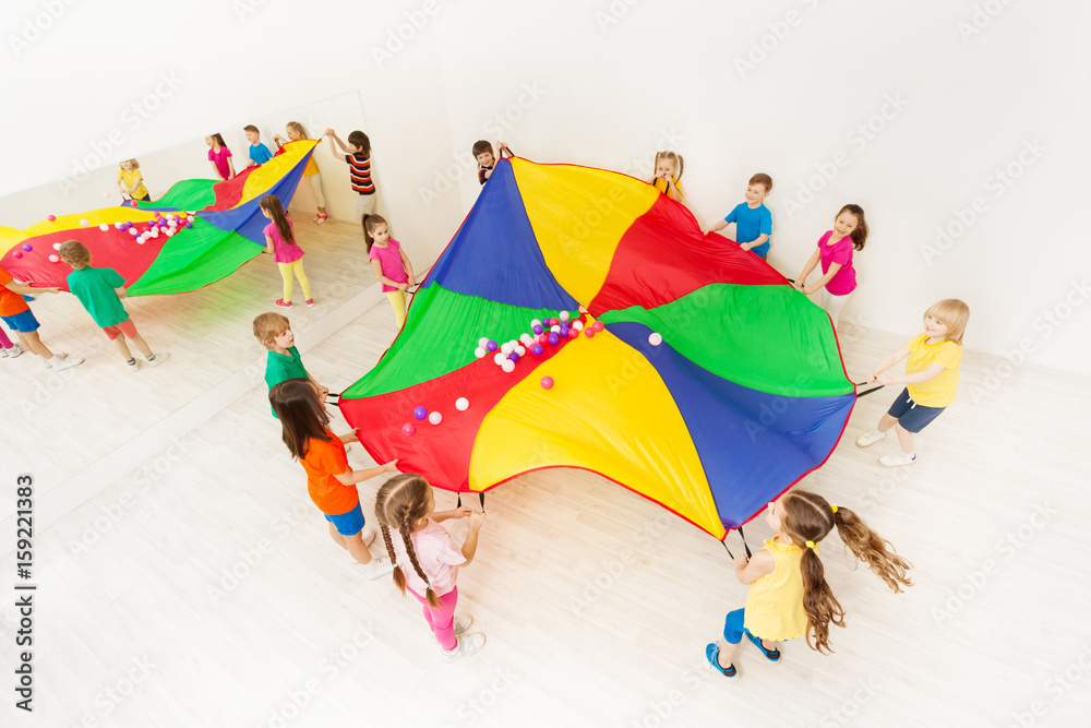 Kids playing parachute games in light gym Stock Photo | Adobe Stock