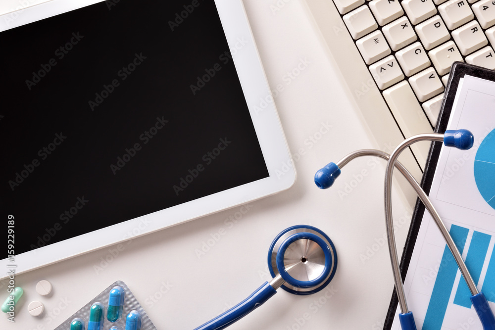 White office desk of a doctor with tablet, computer keyboard, clipboard ...