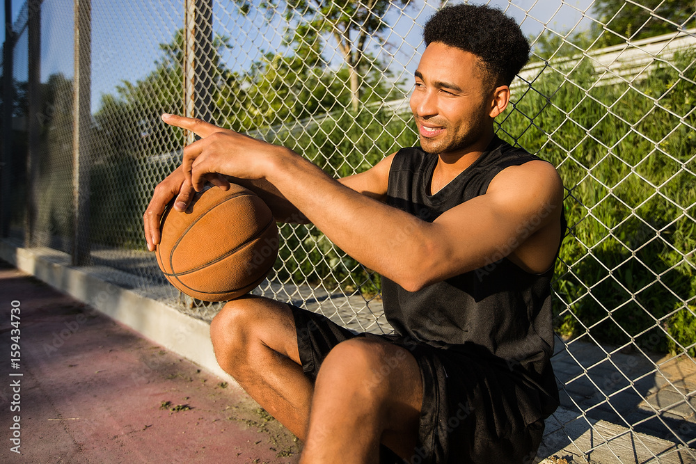 Basketball player is sitting on a basketball court.street ball,sport ...