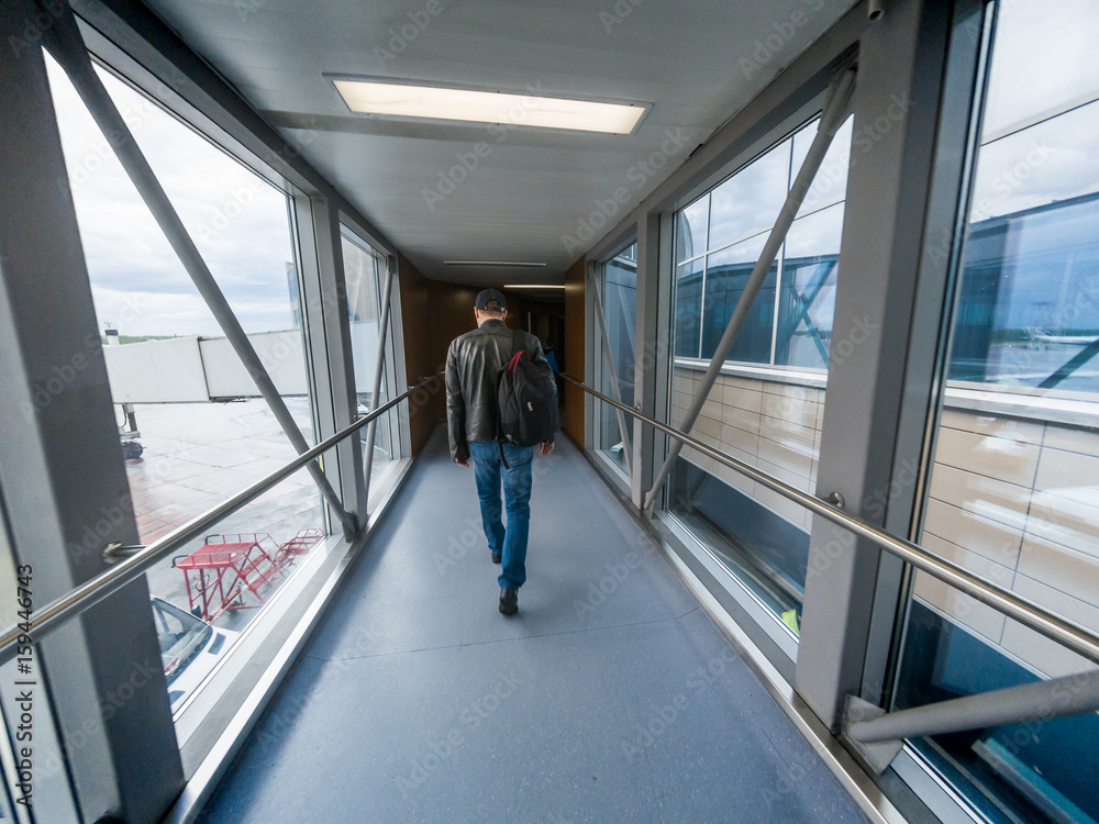 Man boarding in airport gate or jet bridge or jetway or airbridge to a ...