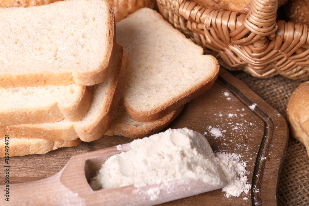 Composition of sliced bread and scoop with flour on cutting board Stock ...