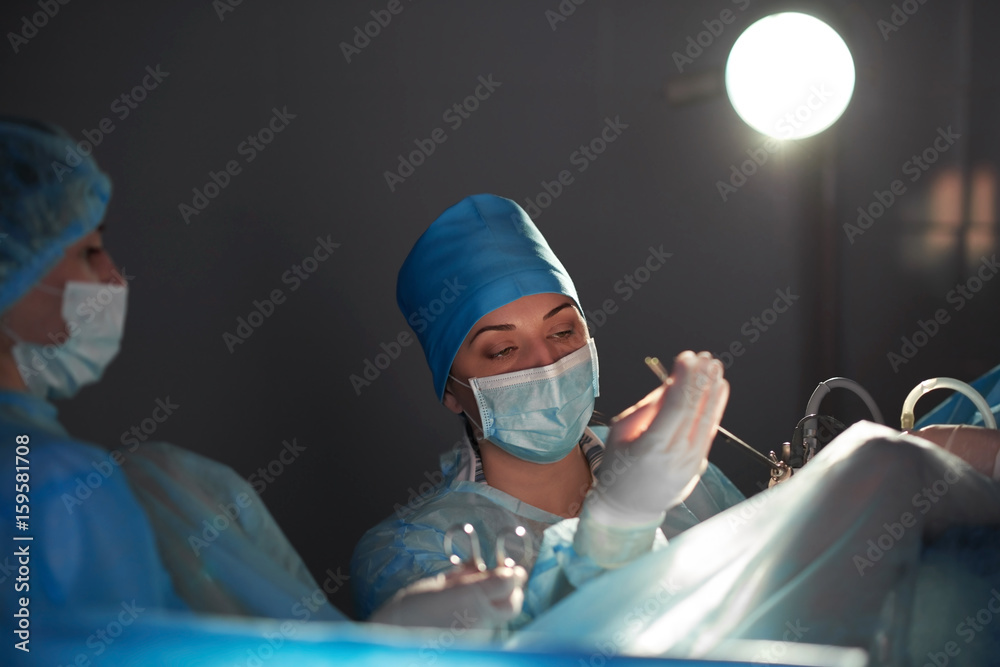 Female surgeon working performing operation with the team of her ...