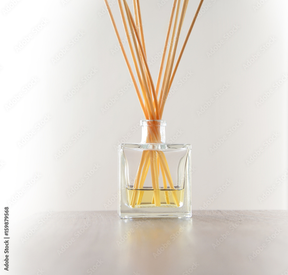 Air refresher with sticks and golden liquid in bright room and white ...