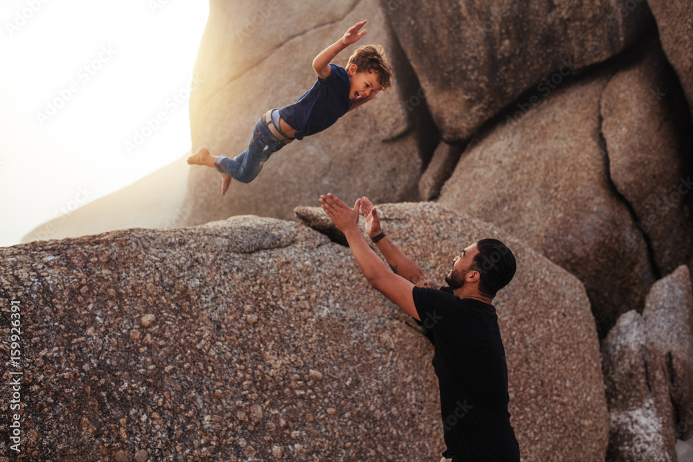 Little boy leaping into his father's arms at the beach Stock Photo ...