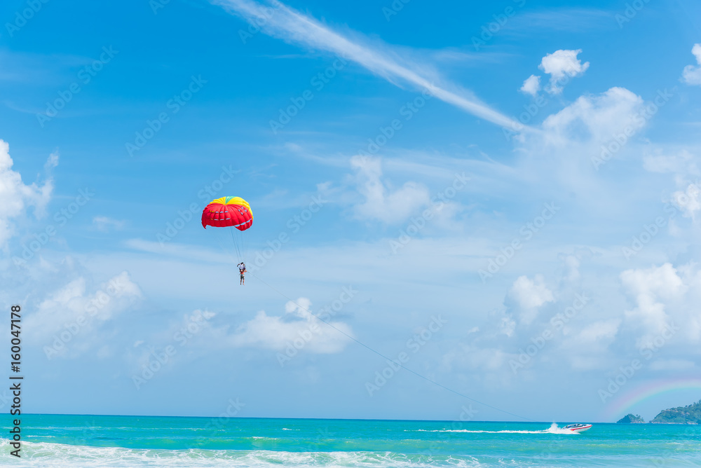 People enjoy parasailing water sport, Flying on a parachute behind a ...
