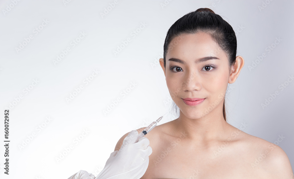 Doctor's hand making injection in girl's face. young asian woman ...