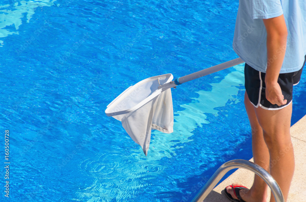 Man wearing shorts cleans the swimming pool with a net Stock Photo ...