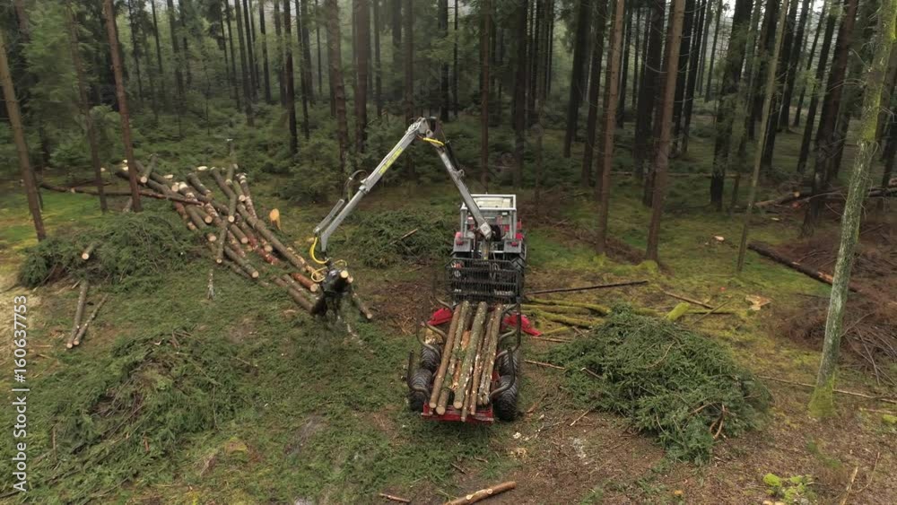AERIAL, CLOSE UP: Flying above logging truck putting pile of delimbed ...