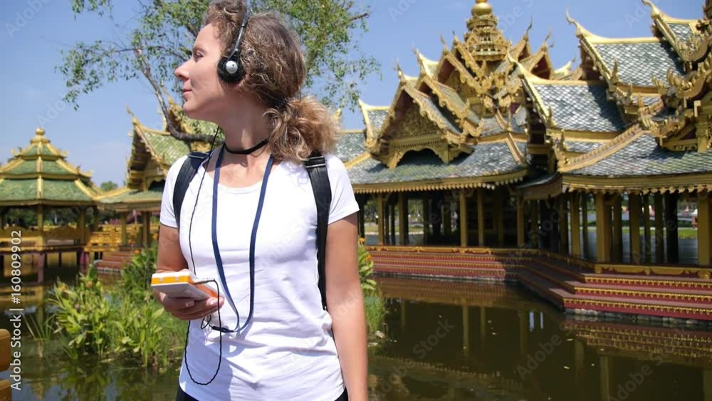 Vídeo do Stock: Female Tourist In Headphones Listening Audio-Guide ...