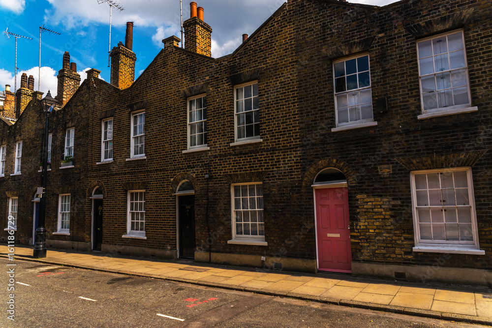 Typical old English buildings, low brick buildings across a narrow ...