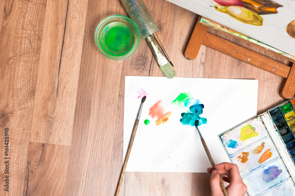Painter draws watercolor picture top view. Drawing lessons, art school ...
