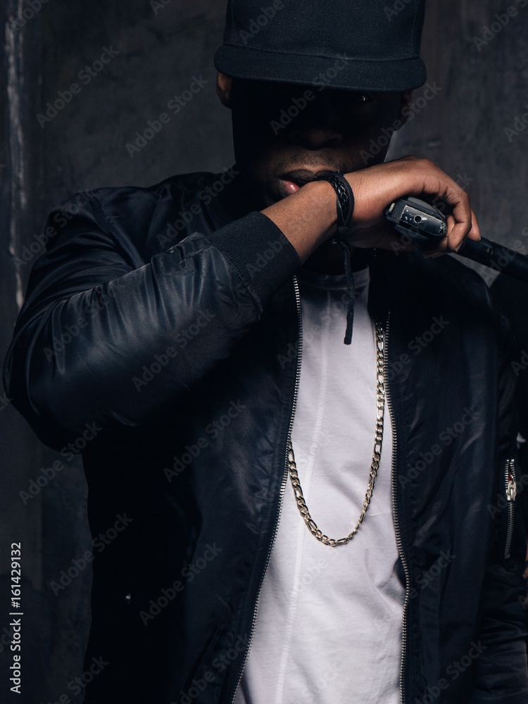 Unrecognizable black criminal with gun closeup studio shoot. Armed ...