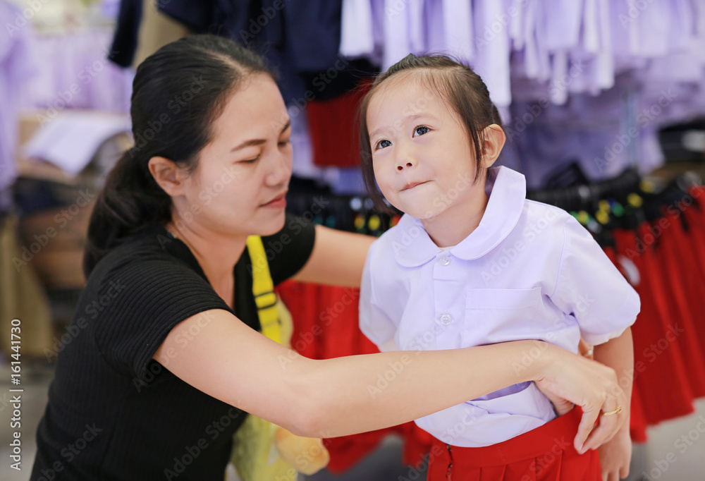 Mother try dressing school uniform for her daughter, Kindergarten ...