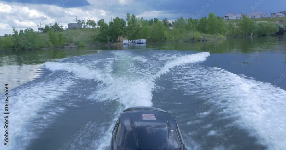 Trail on water surface behind of fast moving motor boat. the motor of ...