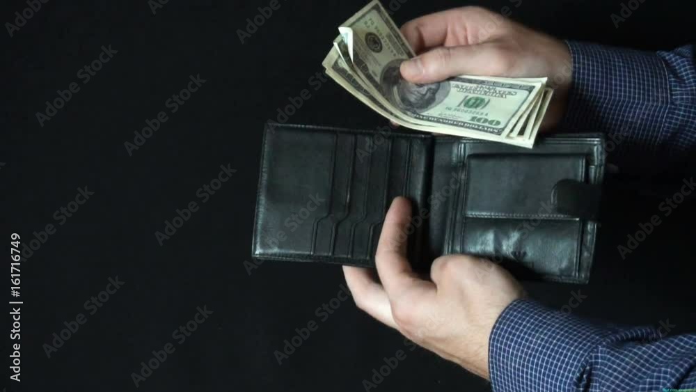 Taking Money Out of a wallet. The man opens a leather wallet and pulls ...