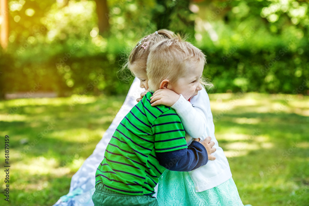 Children hug in the park. 2-3 years. Girl and boy. The concept is ...