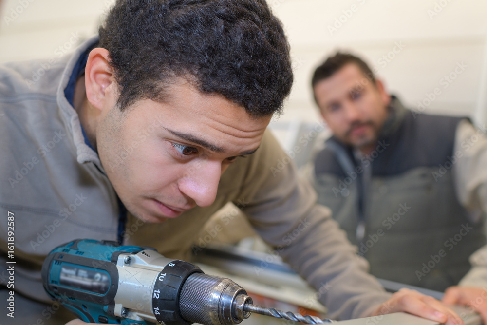 man drilling a hole Stock Photo | Adobe Stock