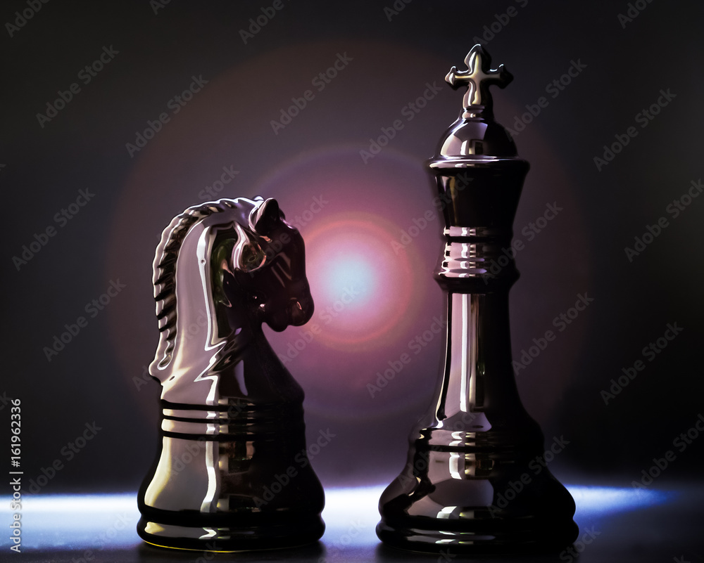 Chess knight facing chess king on black chess board with aura light ...