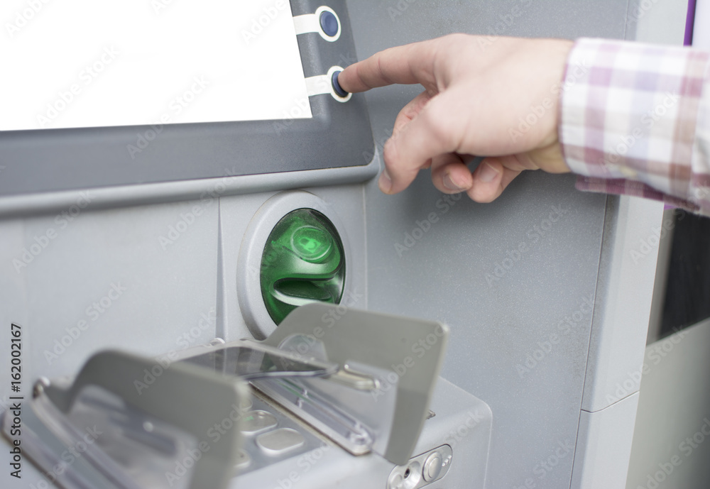 Hand of a man with a credit card, using an ATM. Man using an atm ...