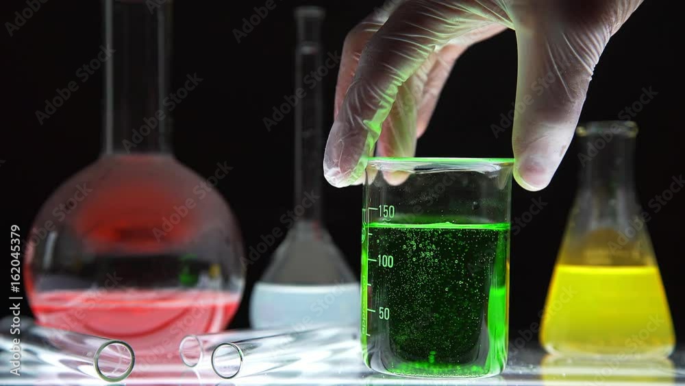 Different types of chemical laboratory glassware with liquids inside: a ...