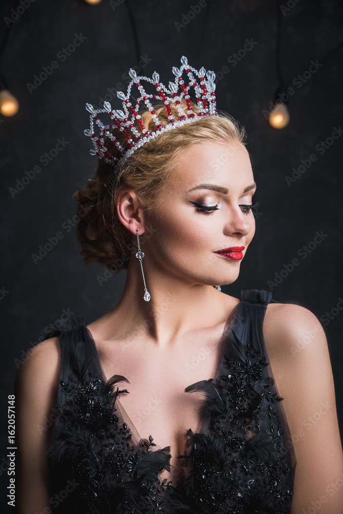 Beautiful woman in crown on dark background Stock Photo | Adobe Stock