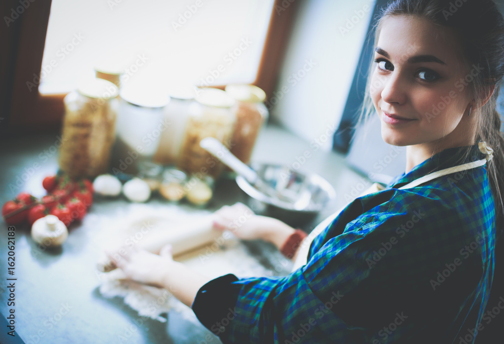 Beautiful woman cooking cake in kitchen standing near desk. Stock Photo ...