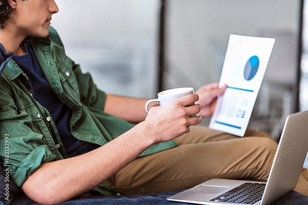 Relaxed young man working on comfortable couch foto de Stock | Adobe Stock
