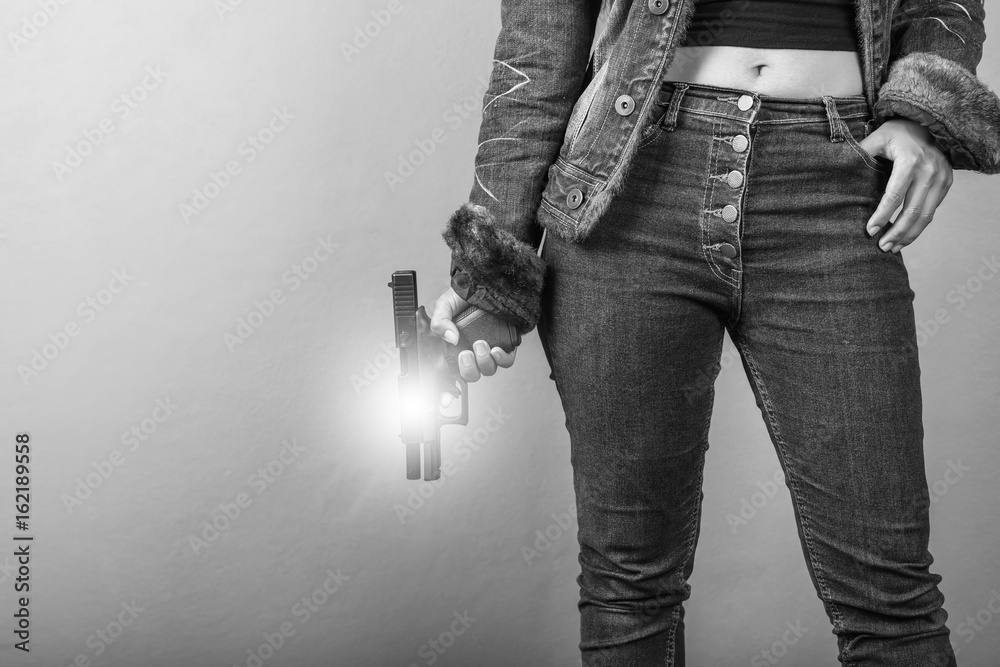 Woman in jeans is holding a gun in her hand with light effect. Stock ...