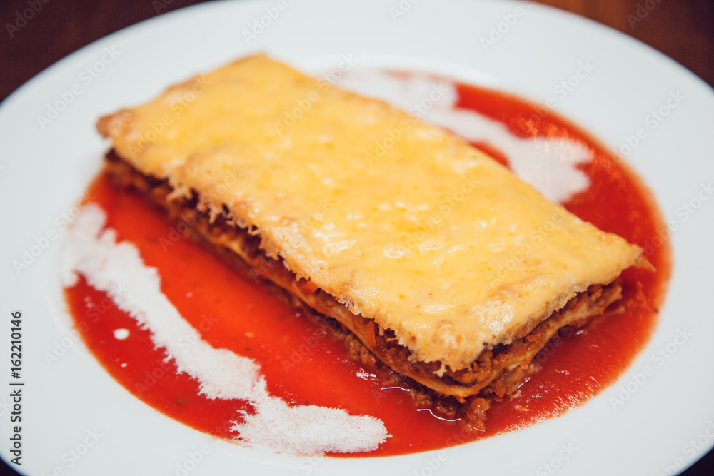 Tasty serving of traditional Italian lasagne with spicy tomato based ...