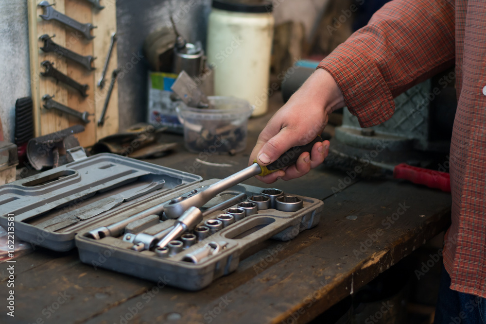 Mechanic take tool from the big set tools, wich lying on the desktop in ...
