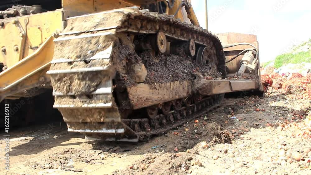 The bulldozer is slowly moving off-road, the bucket and caterpillars of ...