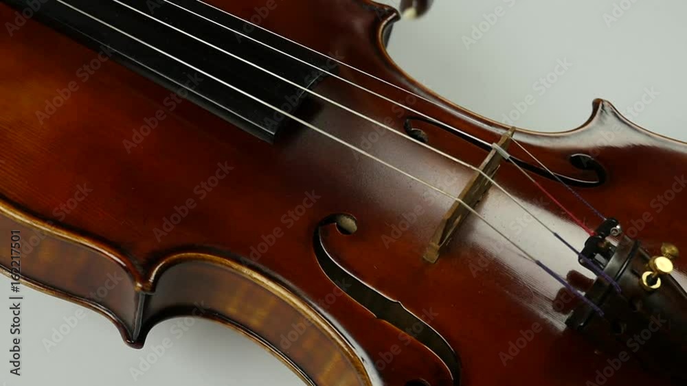 Close up soundboard of violin and bow. The bow moves along the violin ...