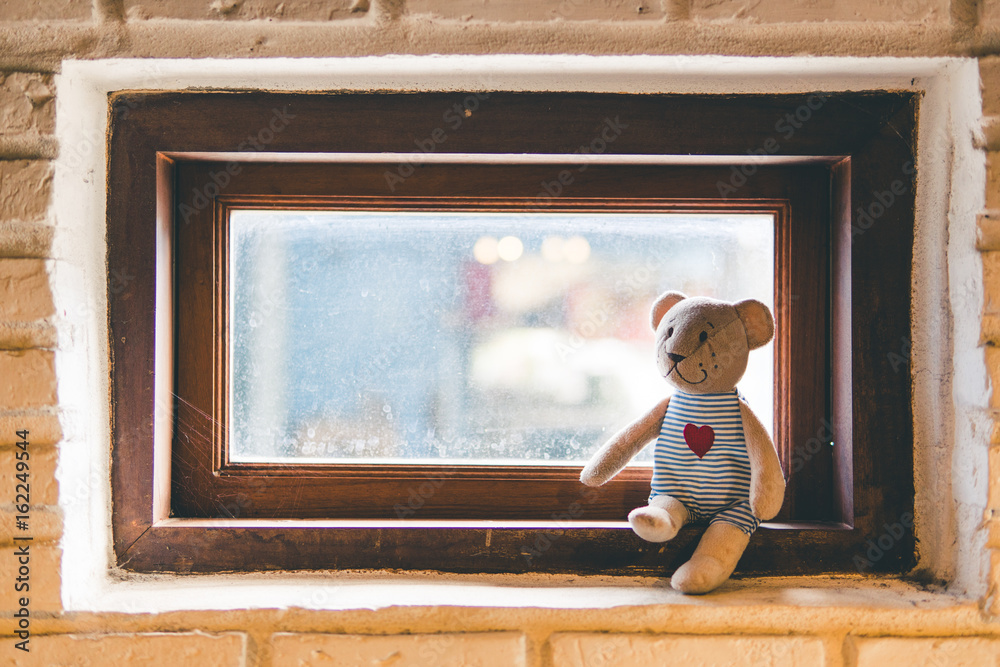lonely bear doll sitting near window,sad emotion symbol,waiting for ...