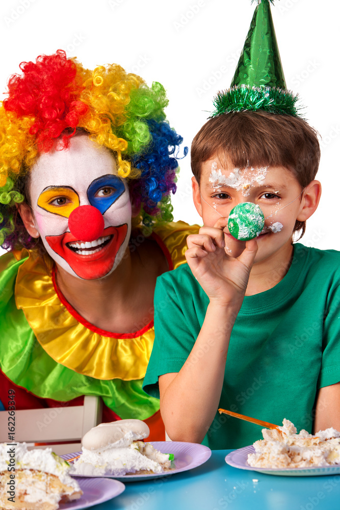 Birthday child clown eating cake with girl together. Kid with messy ...