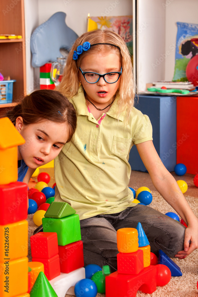 Children building blocks in kindergarten. Group kids playing toy on ...
