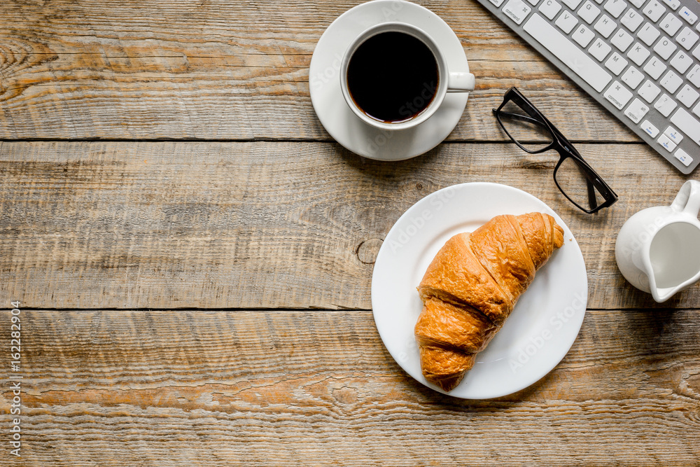 coffee and croissant for breakfast of businessman wooden office desk ...