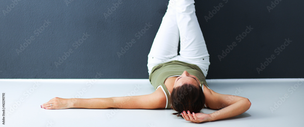 Young woman lying on the floor with legs up Stock Photo | Adobe Stock