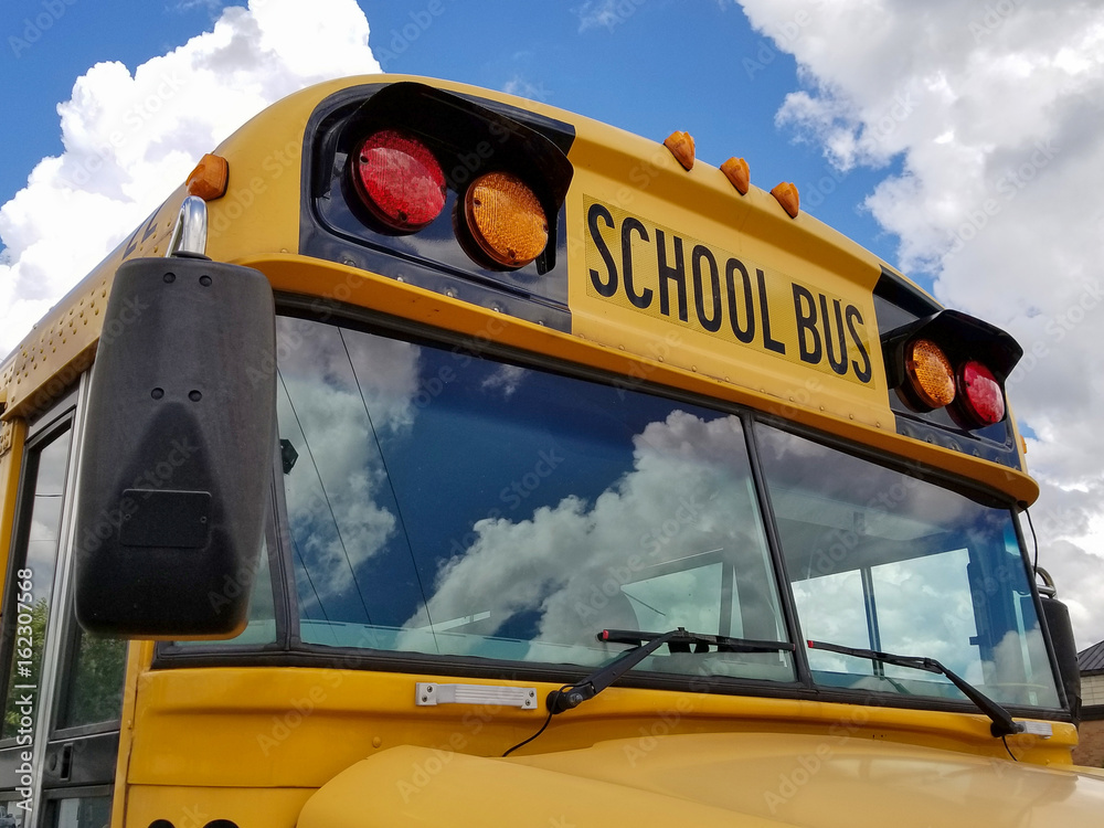 yellow school bus with cloud reflection in windshield Stock Photo ...