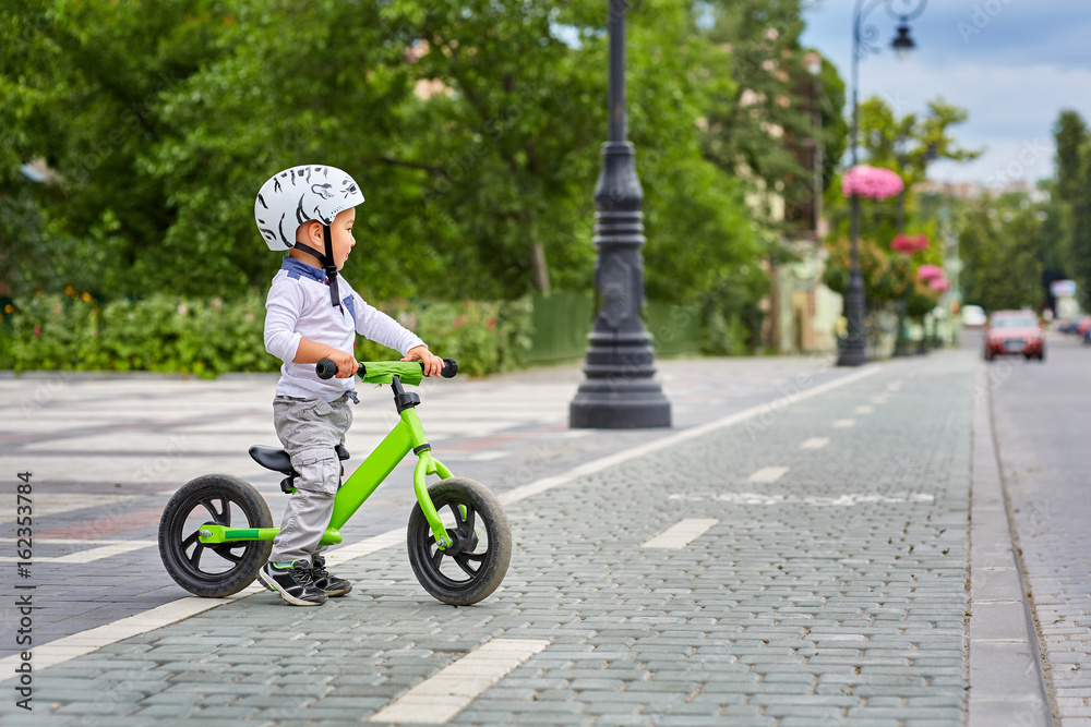 Child boy in white helmet riding on his first bike with a helmet. Bike ...
