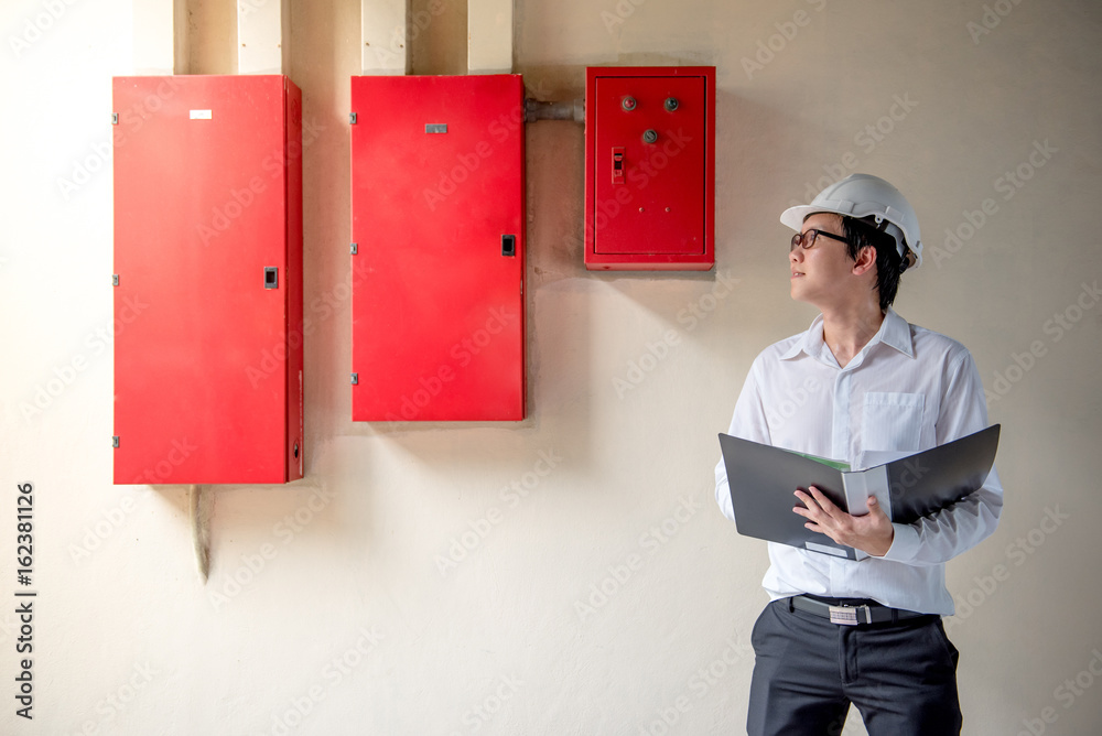 Young Asian Electrical Engineer holding files while wearing a personal ...