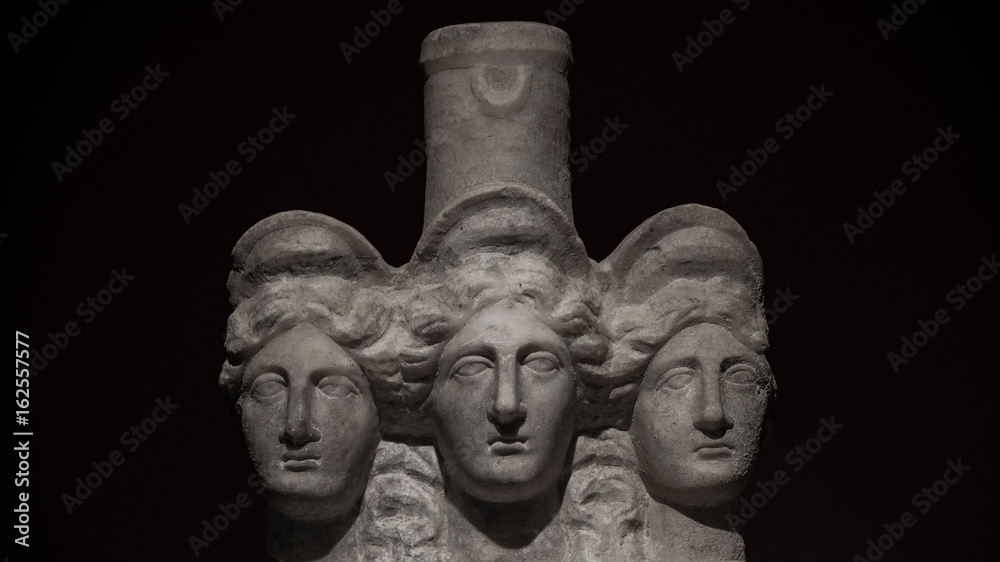 Three headed roman-asian ancient statue of beautiful women at black ...