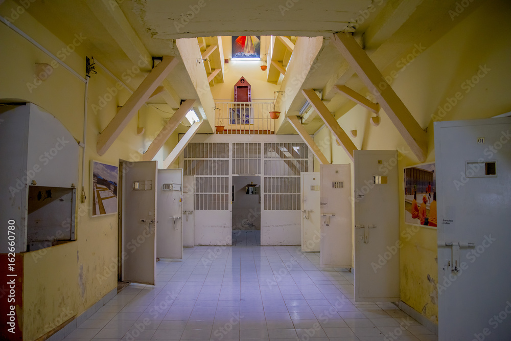 Indoor view of old deserted rugged building, cells of prisoners with ...
